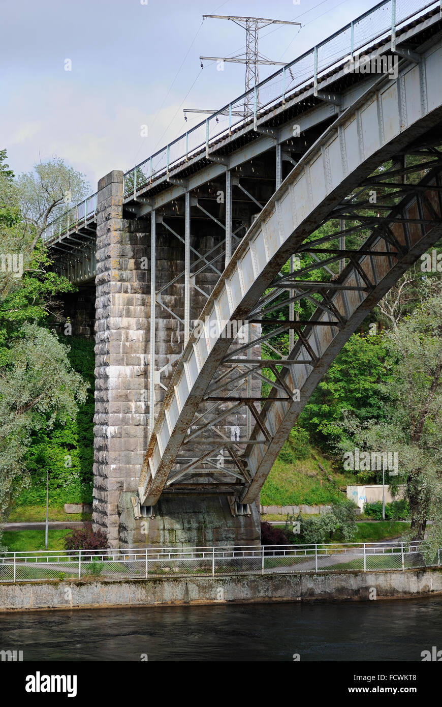 Arch railway bridge overlooking the river embankment near the town of ...