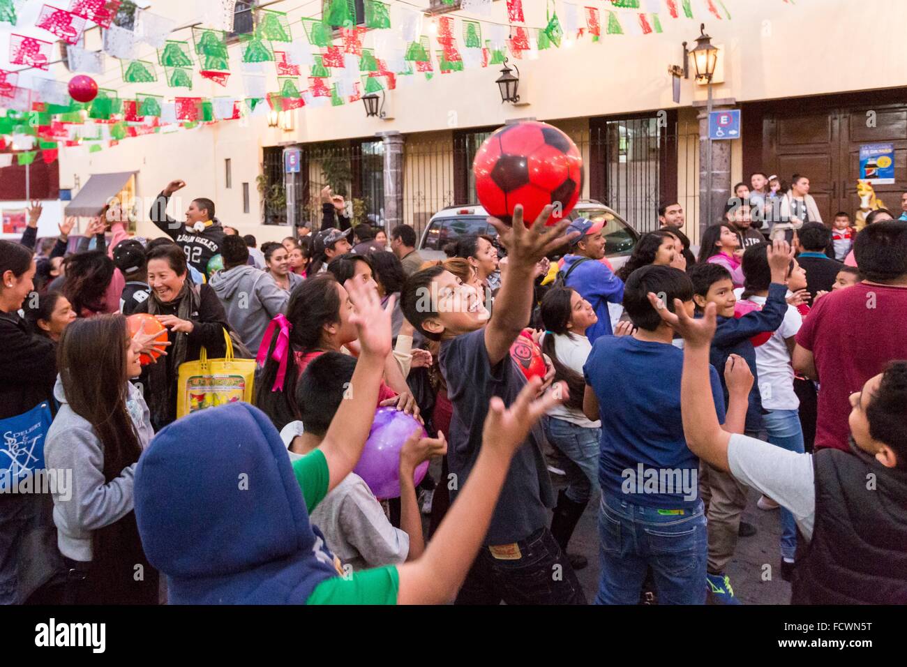 Children jump to catch toys thrown into the crowd during during El Dia ...