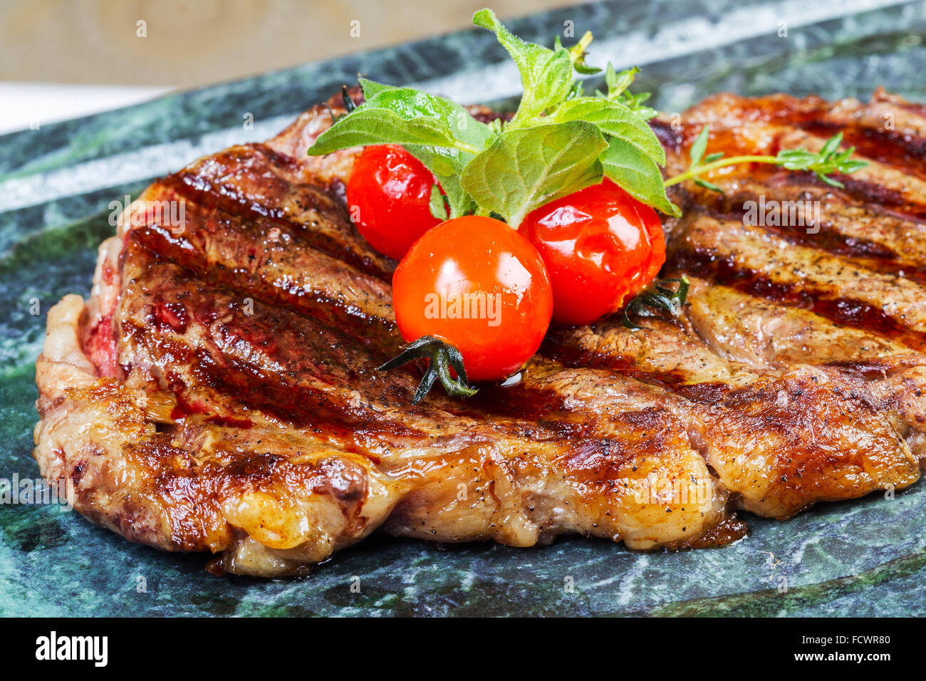 grilled meat with tomatoes on a marble tray Stock Photo - Alamy