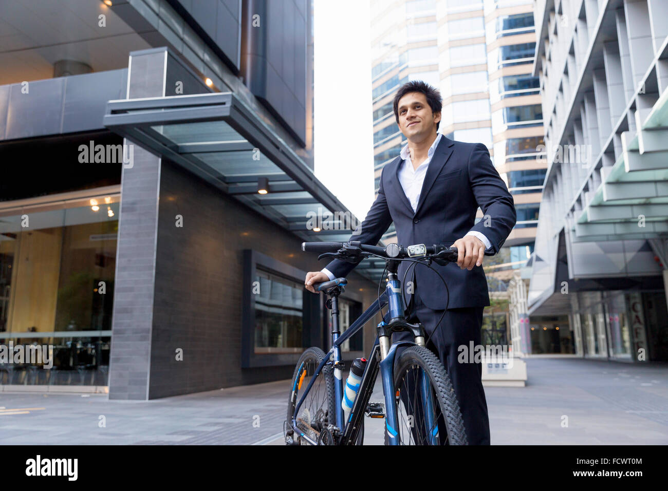 Successful businessman in suit riding bicycle Stock Photo - Alamy