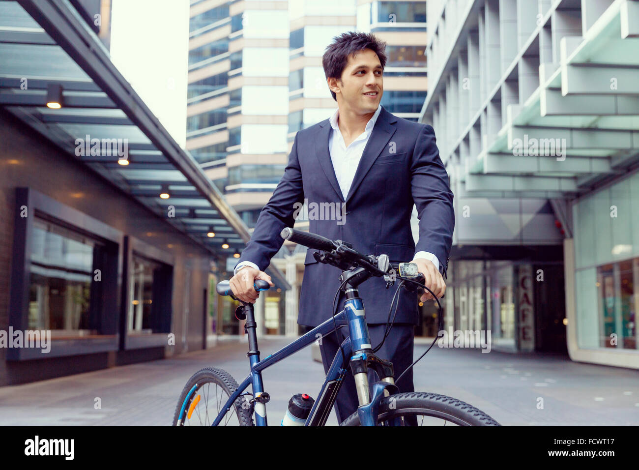 Successful businessman in suit riding bicycle Stock Photo - Alamy
