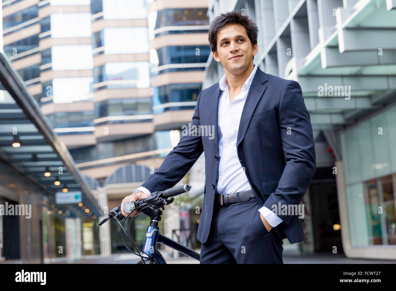 Successful businessman in suit riding bicycle Stock Photo - Alamy
