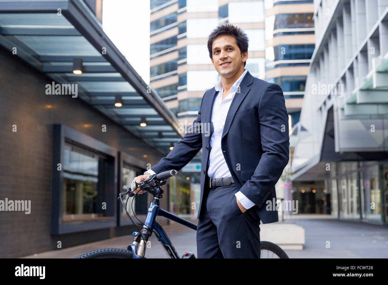 Successful businessman in suit riding bicycle Stock Photo - Alamy