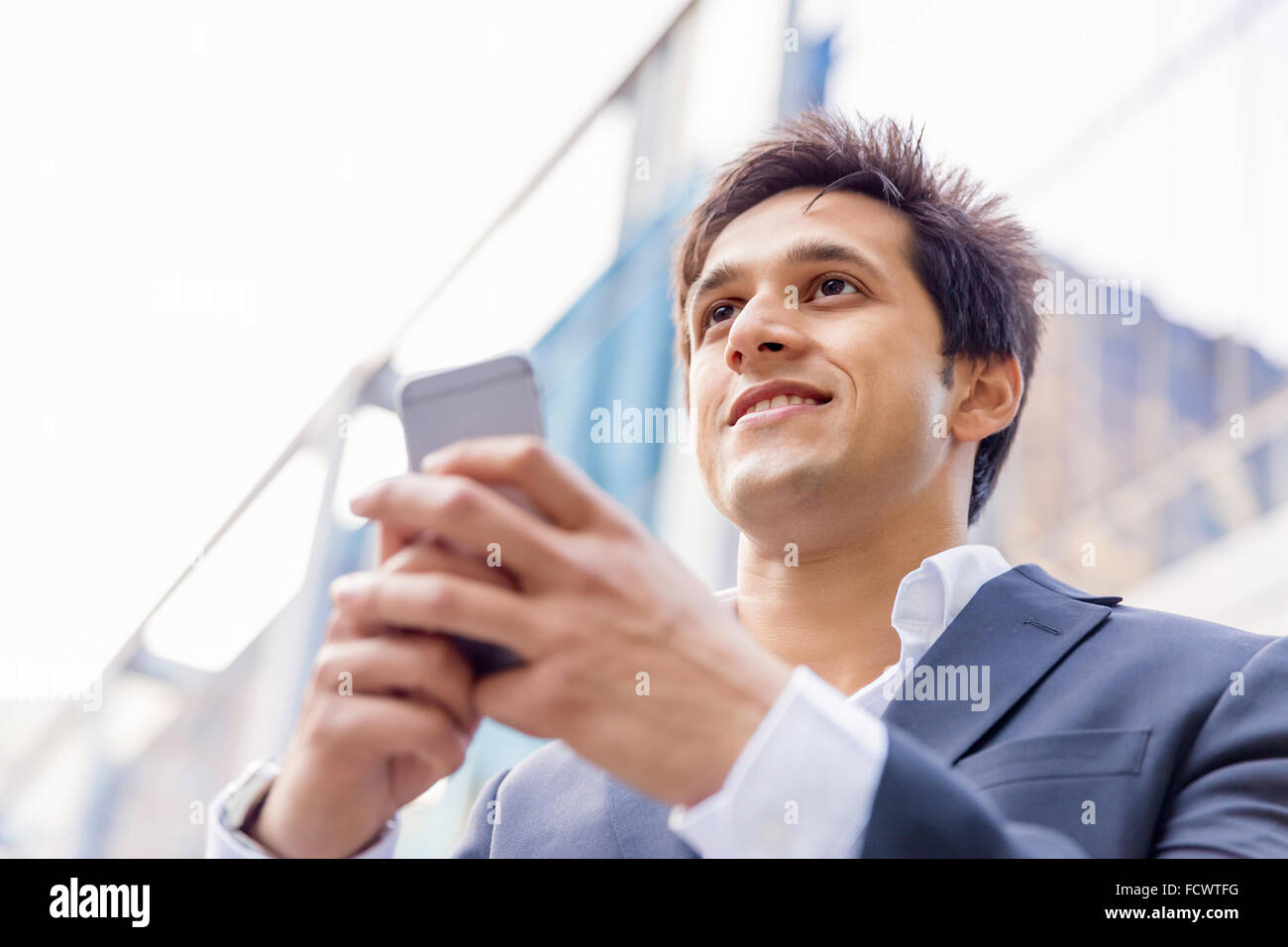 Portrait of confident businessman holding hs mobile phone outdoors Stock Photo - Alamy
