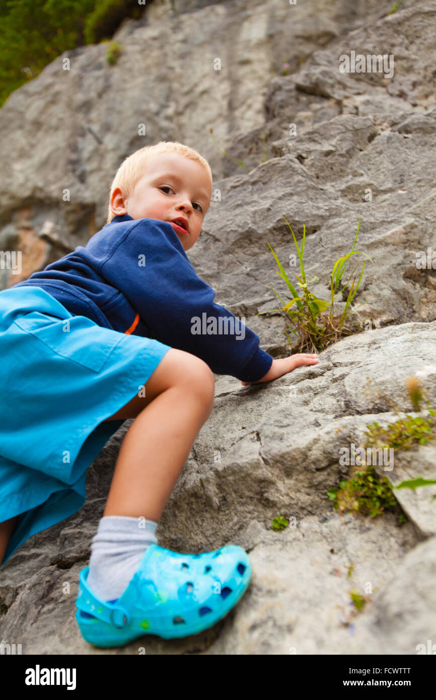 Little boy climbing on a rock in the Austrian Alps Stock Photo - Alamy