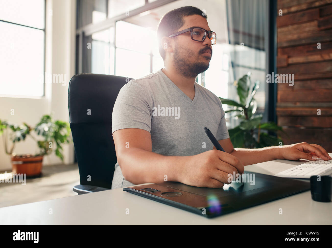 Portrait of young male photo editor at work in his office. Male graphic ...