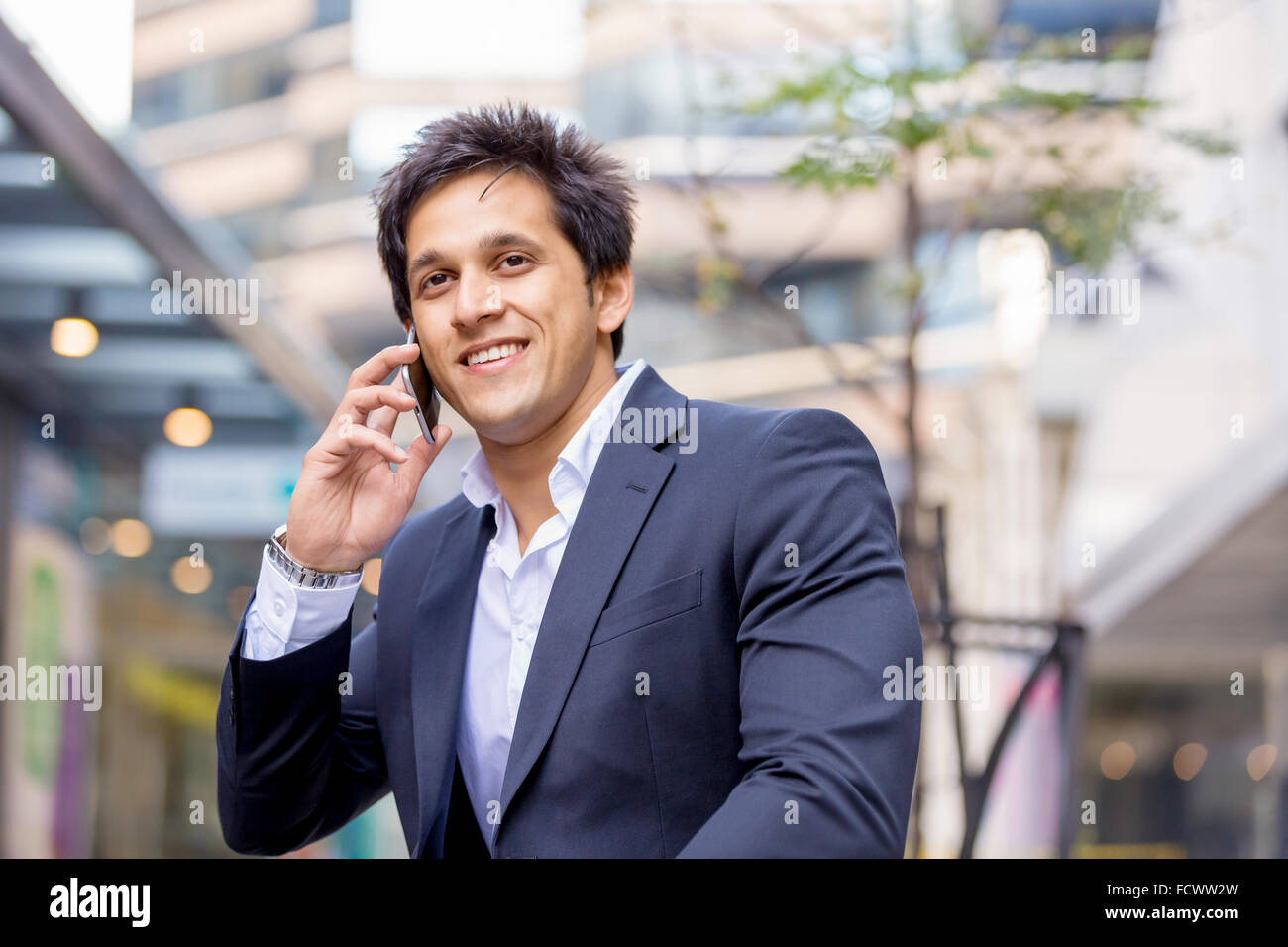 Portrait of confident businessman holding hs mobile phone outdoors Stock Photo - Alamy