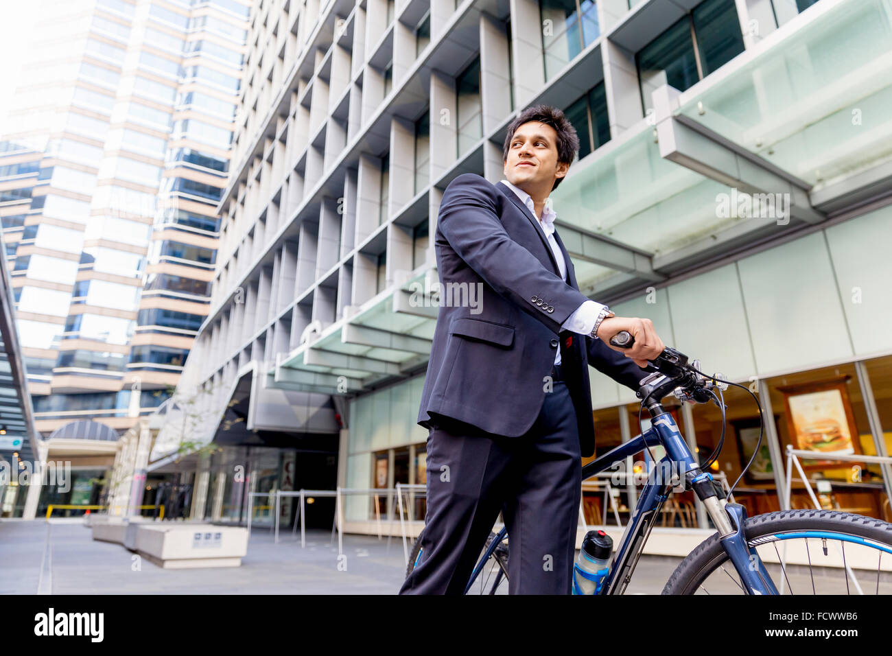 Successful businessman in suit riding bicycle Stock Photo - Alamy