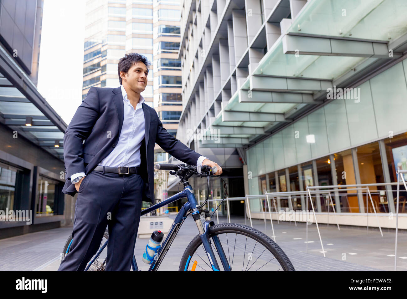 Successful businessman in suit riding bicycle Stock Photo - Alamy