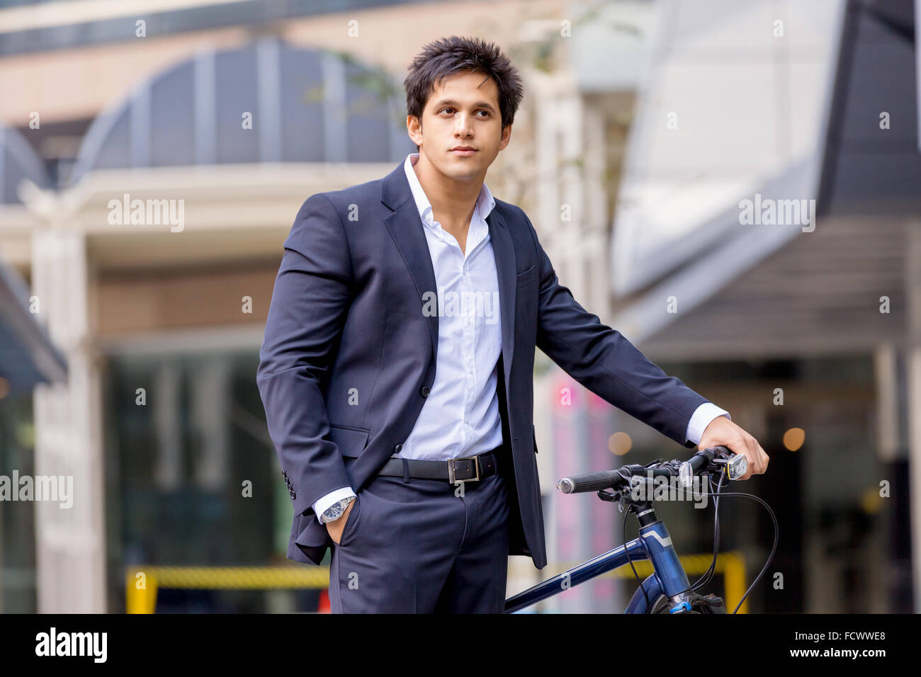 Successful businessman in suit riding bicycle Stock Photo - Alamy