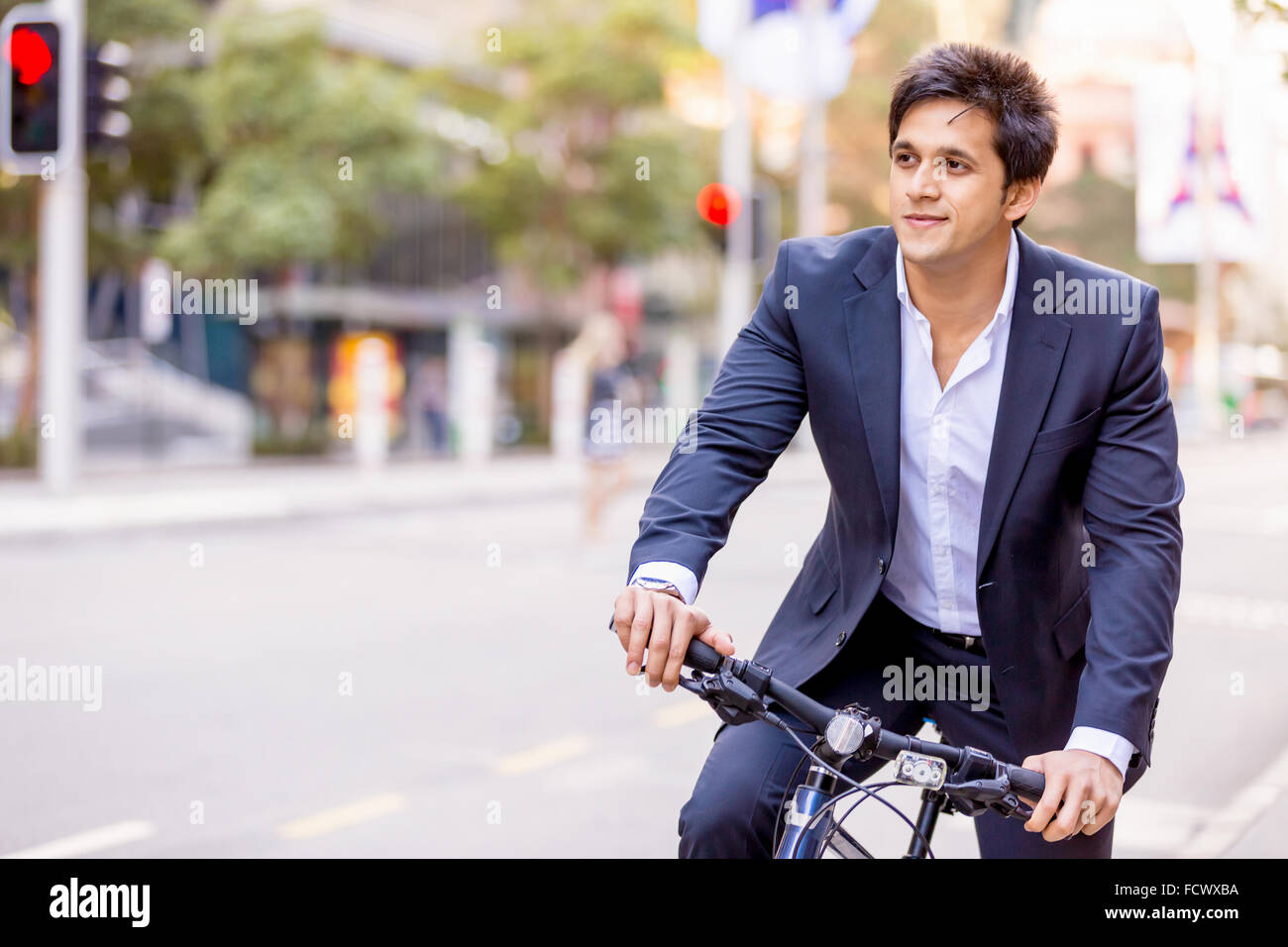 Successful businessman in suit riding bicycle Stock Photo - Alamy