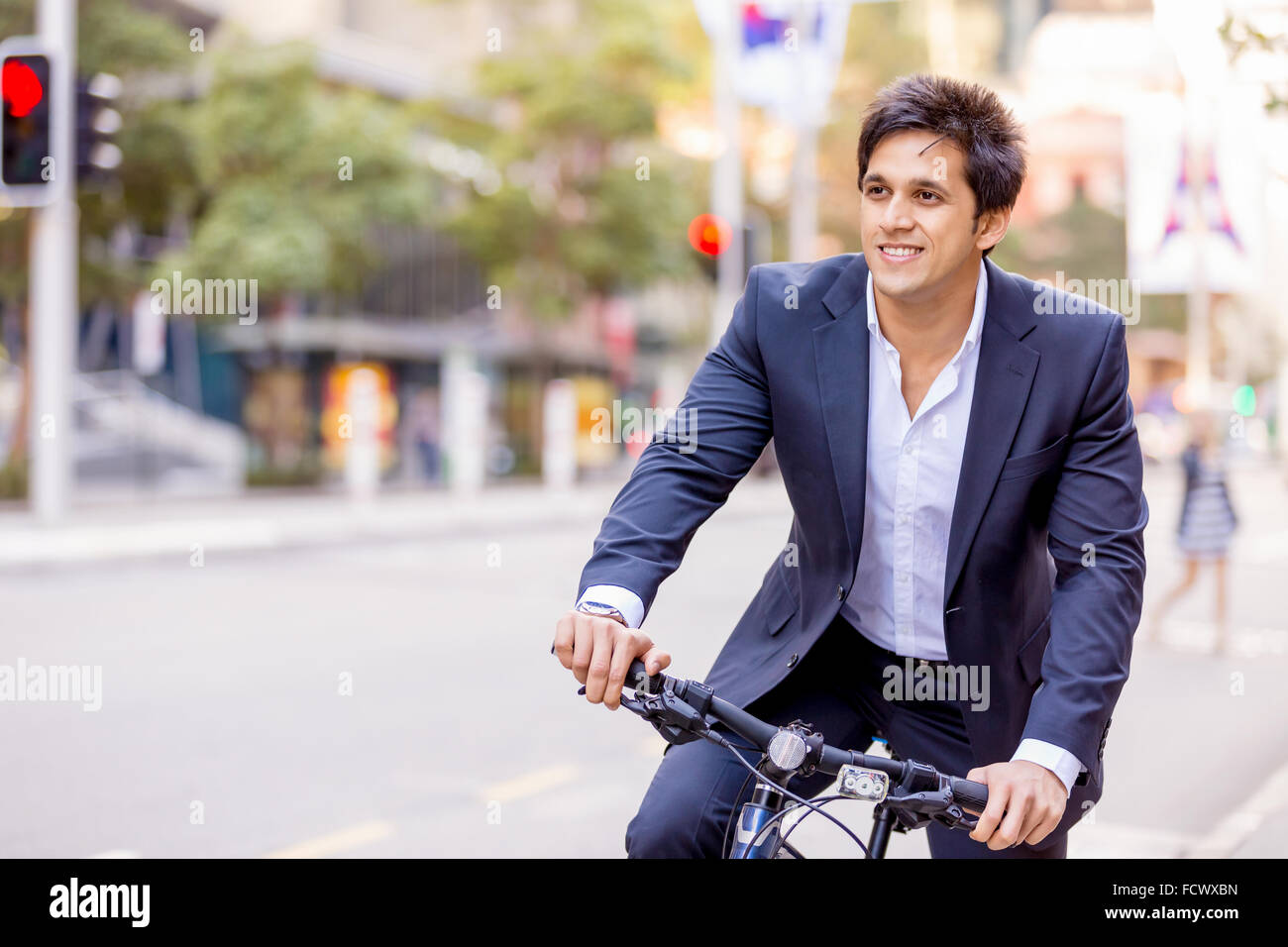 Successful businessman in suit riding bicycle Stock Photo - Alamy