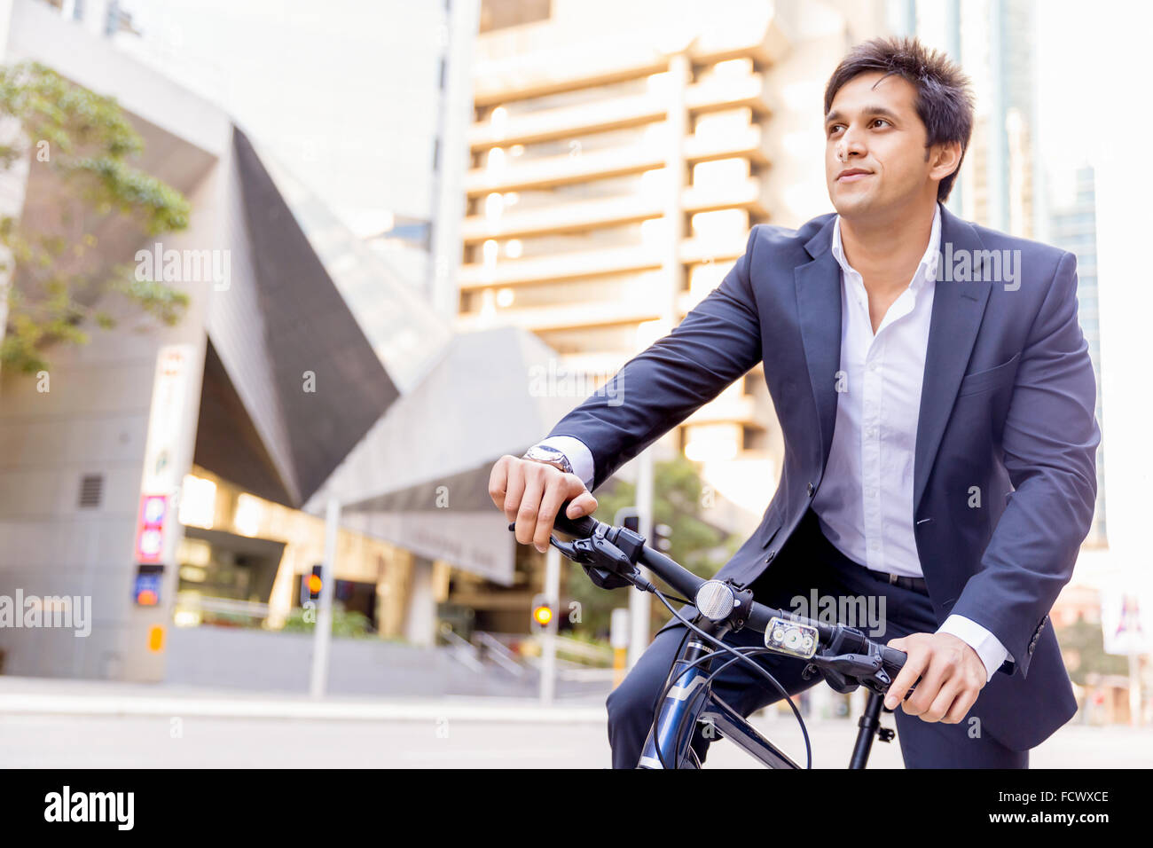 Successful businessman in suit riding bicycle Stock Photo - Alamy