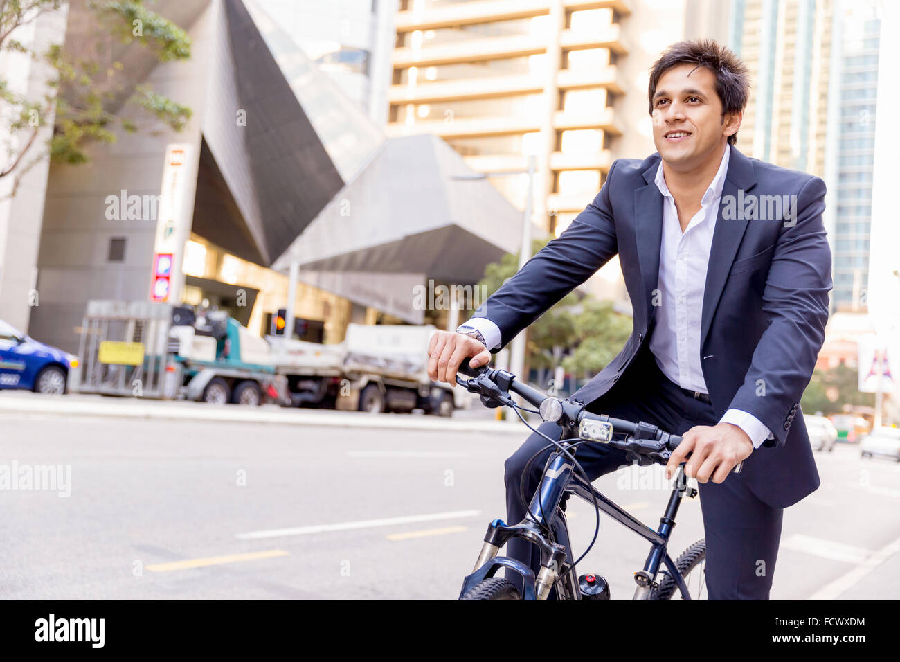 Successful businessman in suit riding bicycle Stock Photo - Alamy