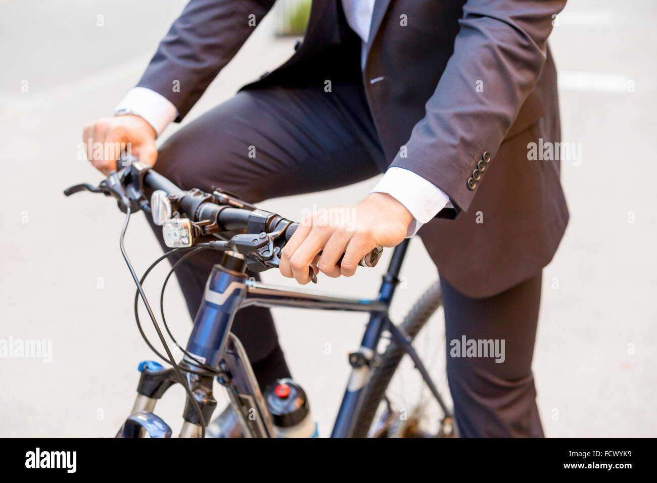 Successful businessman in suit riding bicycle Stock Photo - Alamy