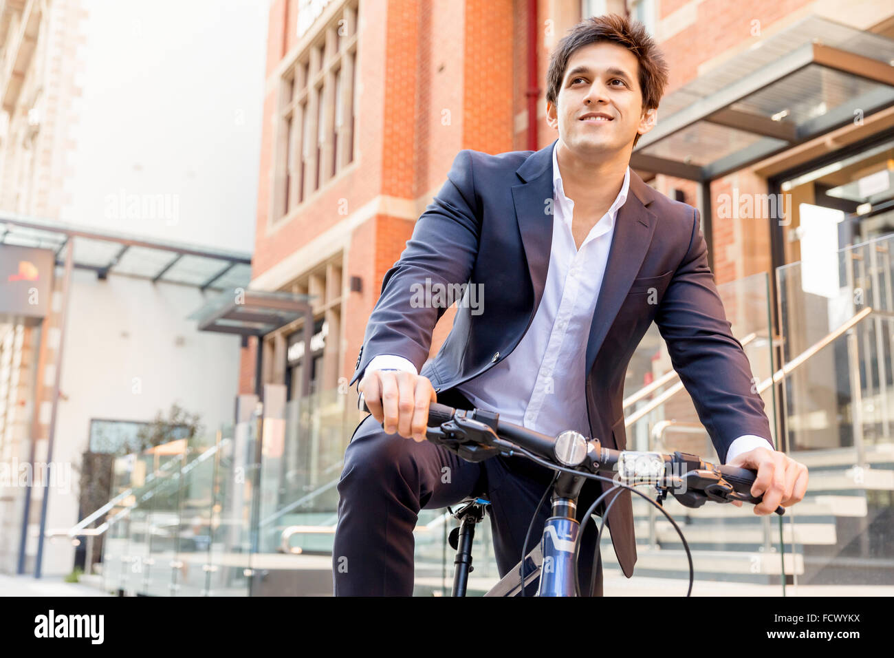 Successful businessman in suit riding bicycle Stock Photo - Alamy