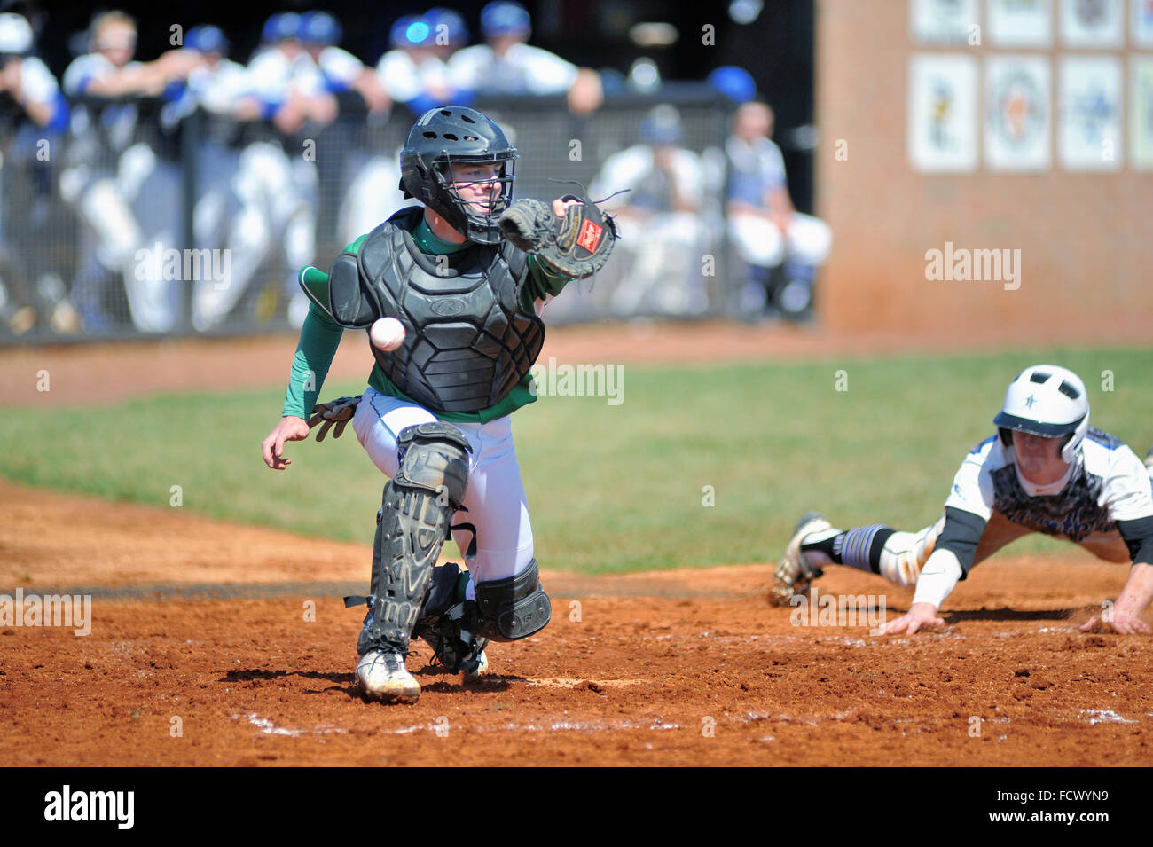 A high school catcher is unable to secure a throw from the first ...