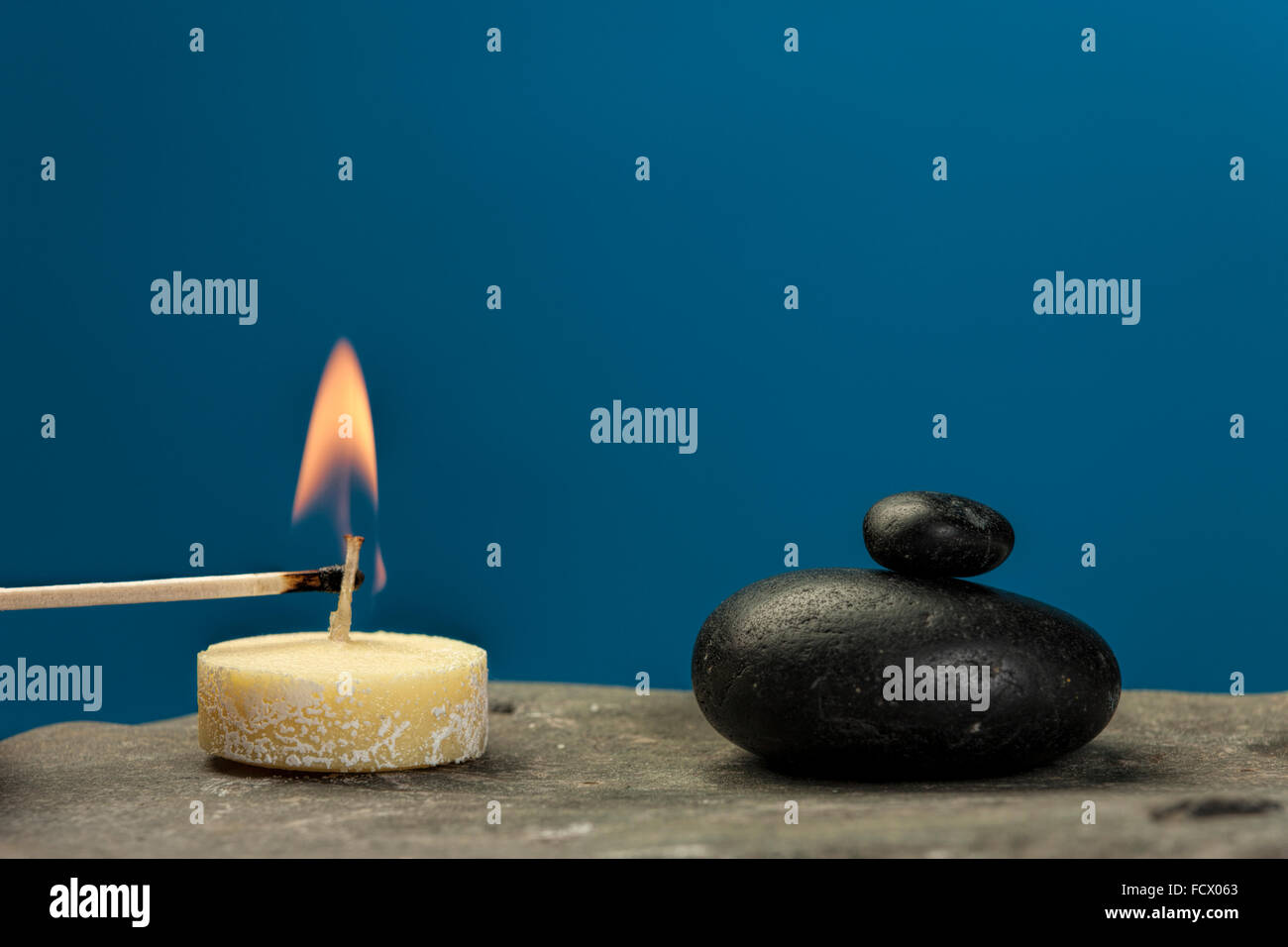 Lighting a small candle on rock Stock Photo - Alamy