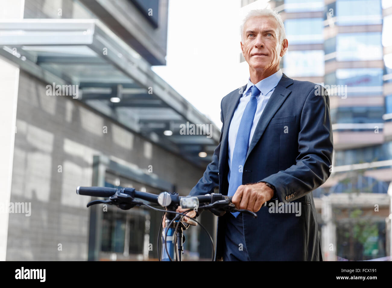 Successful businessman in suit riding bicycle Stock Photo - Alamy