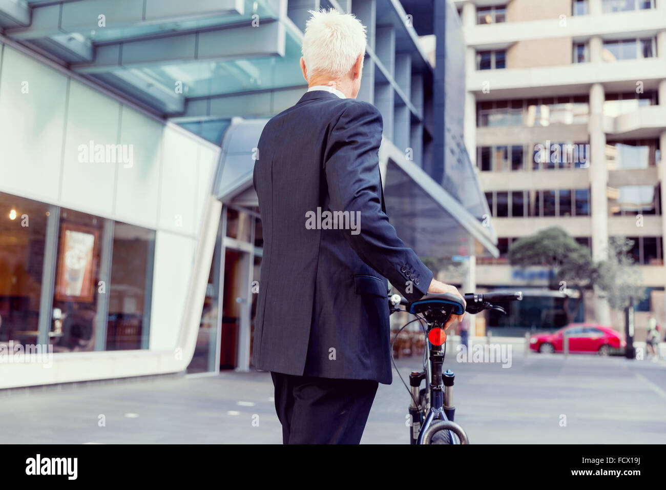 Successful businessman in suit riding bicycle Stock Photo - Alamy