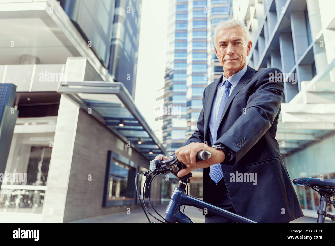 Successful businessman in suit riding bicycle Stock Photo - Alamy