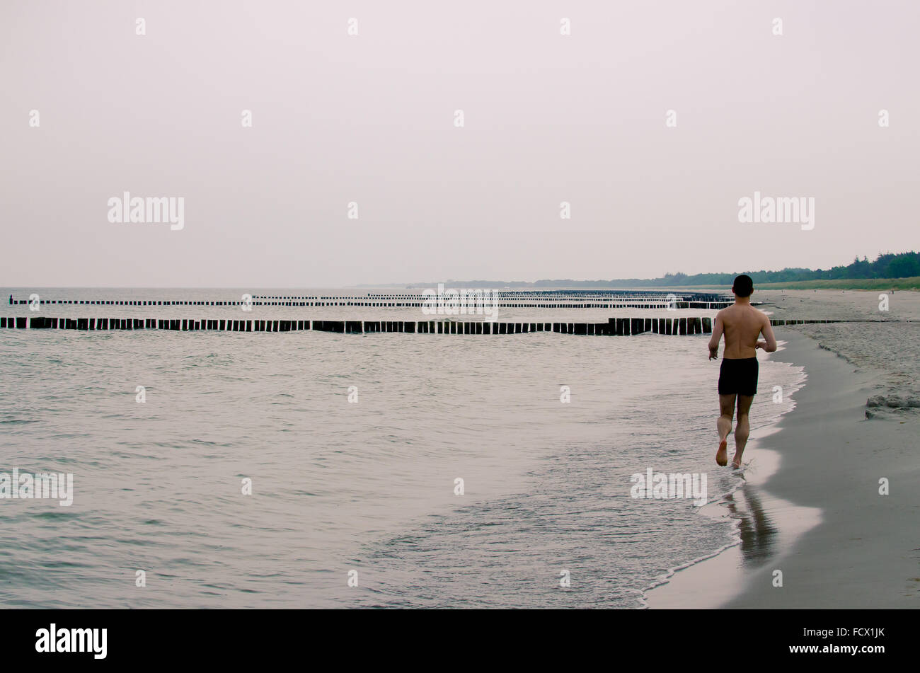 Man running into waves hi-res stock photography and images - Alamy