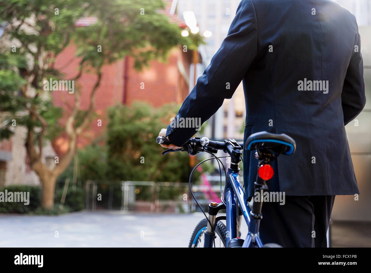 Successful businessman in suit riding bicycle Stock Photo - Alamy