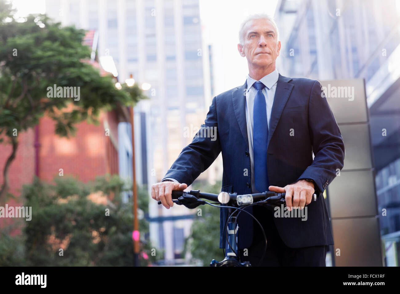 Successful businessman in suit riding bicycle Stock Photo - Alamy