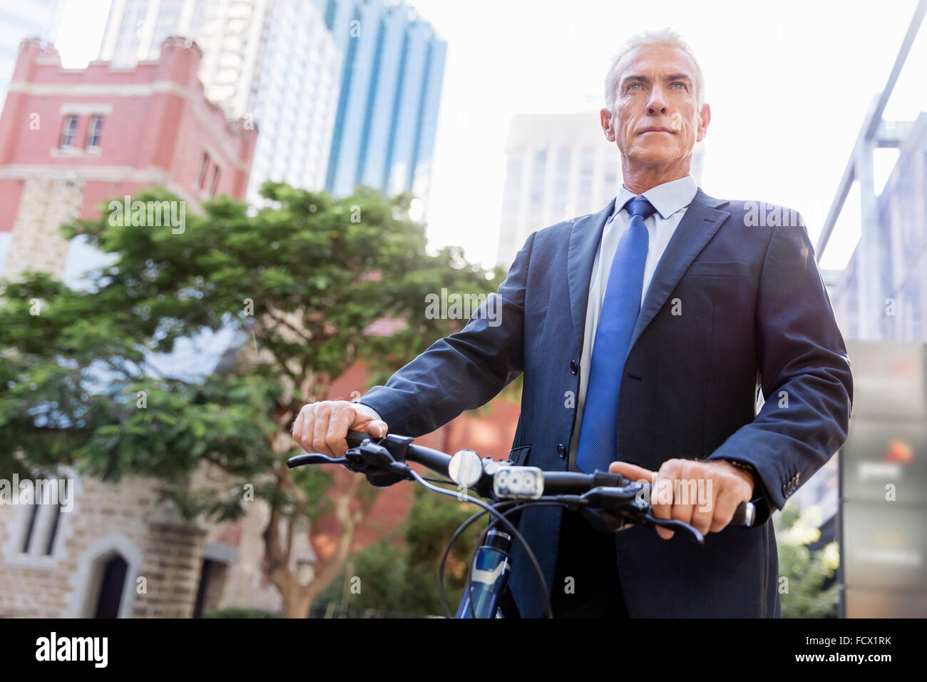 Successful businessman in suit riding bicycle Stock Photo - Alamy