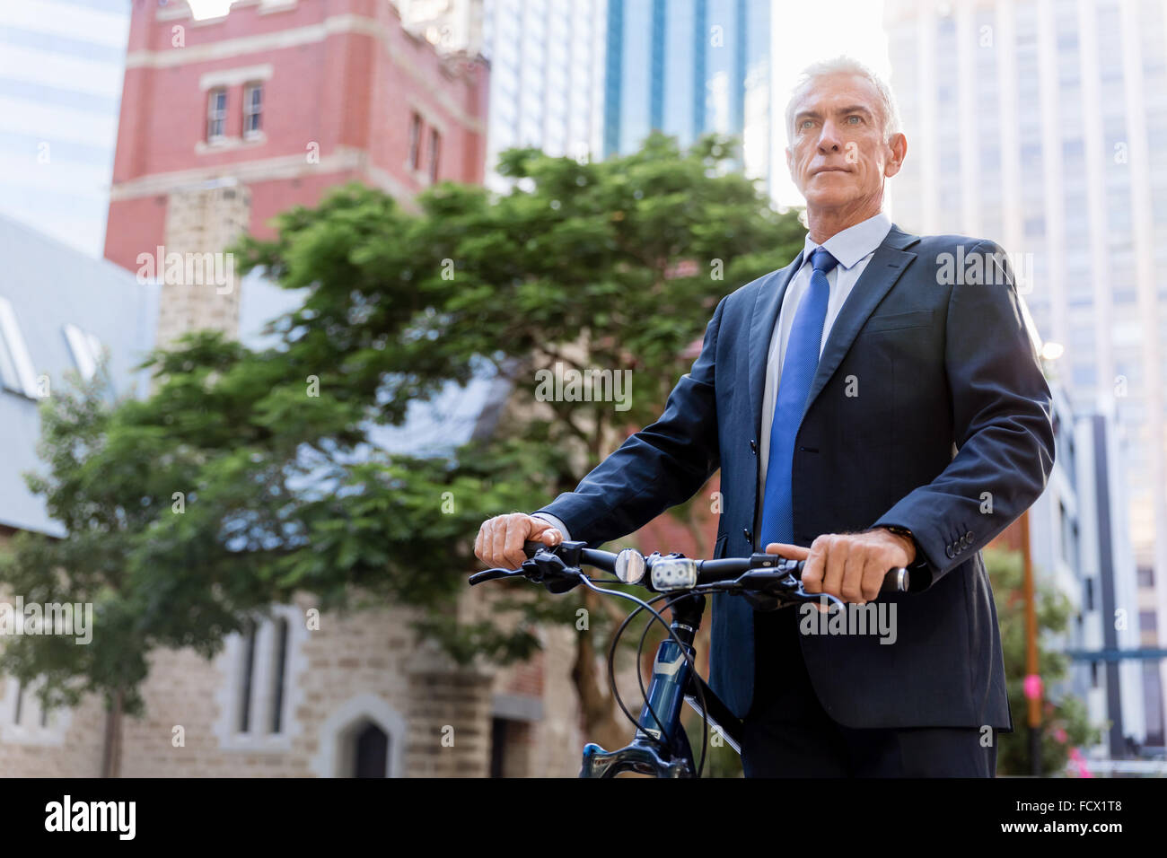 Successful businessman in suit riding bicycle Stock Photo - Alamy