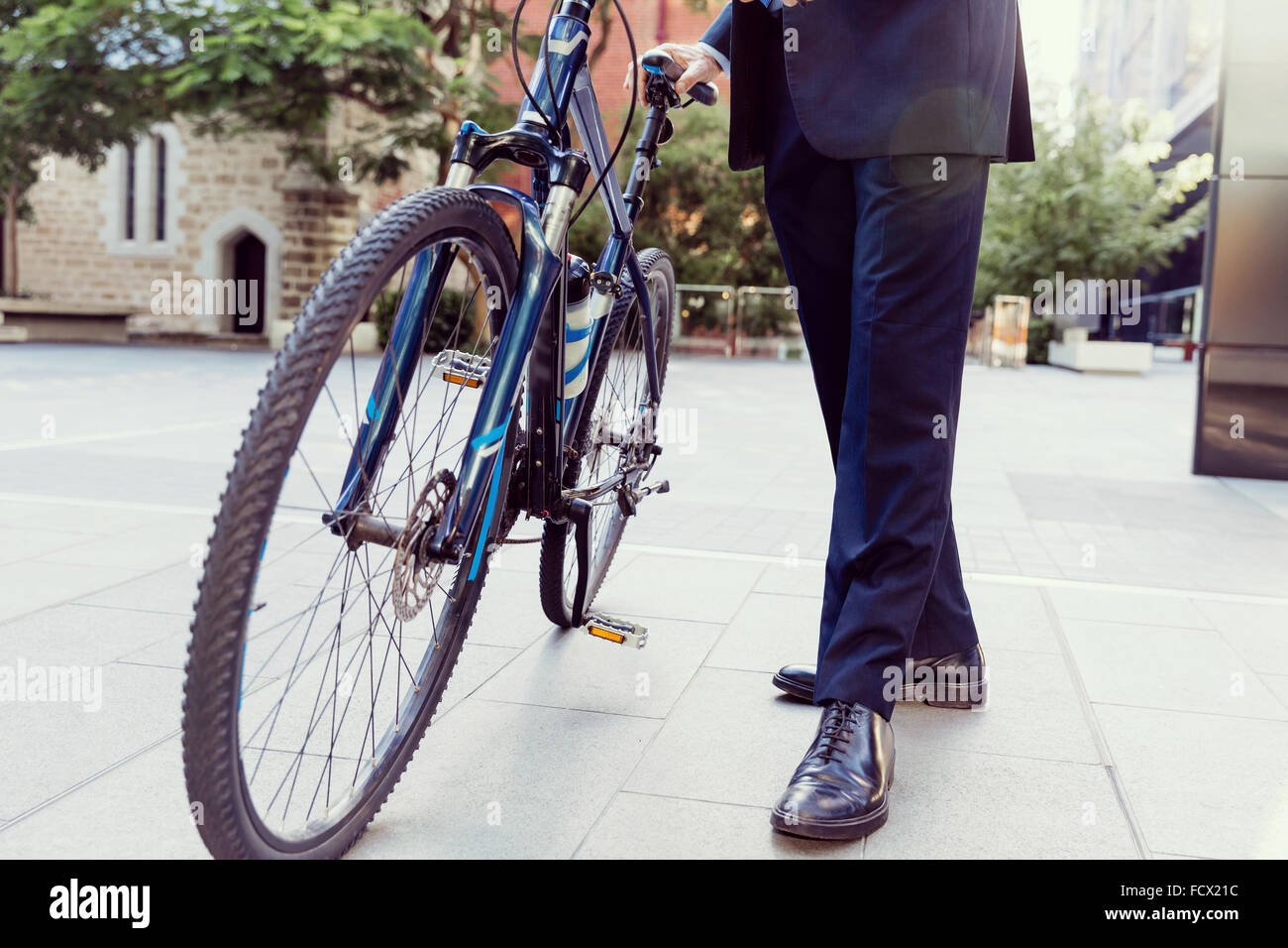Successful businessman in suit riding bicycle Stock Photo - Alamy