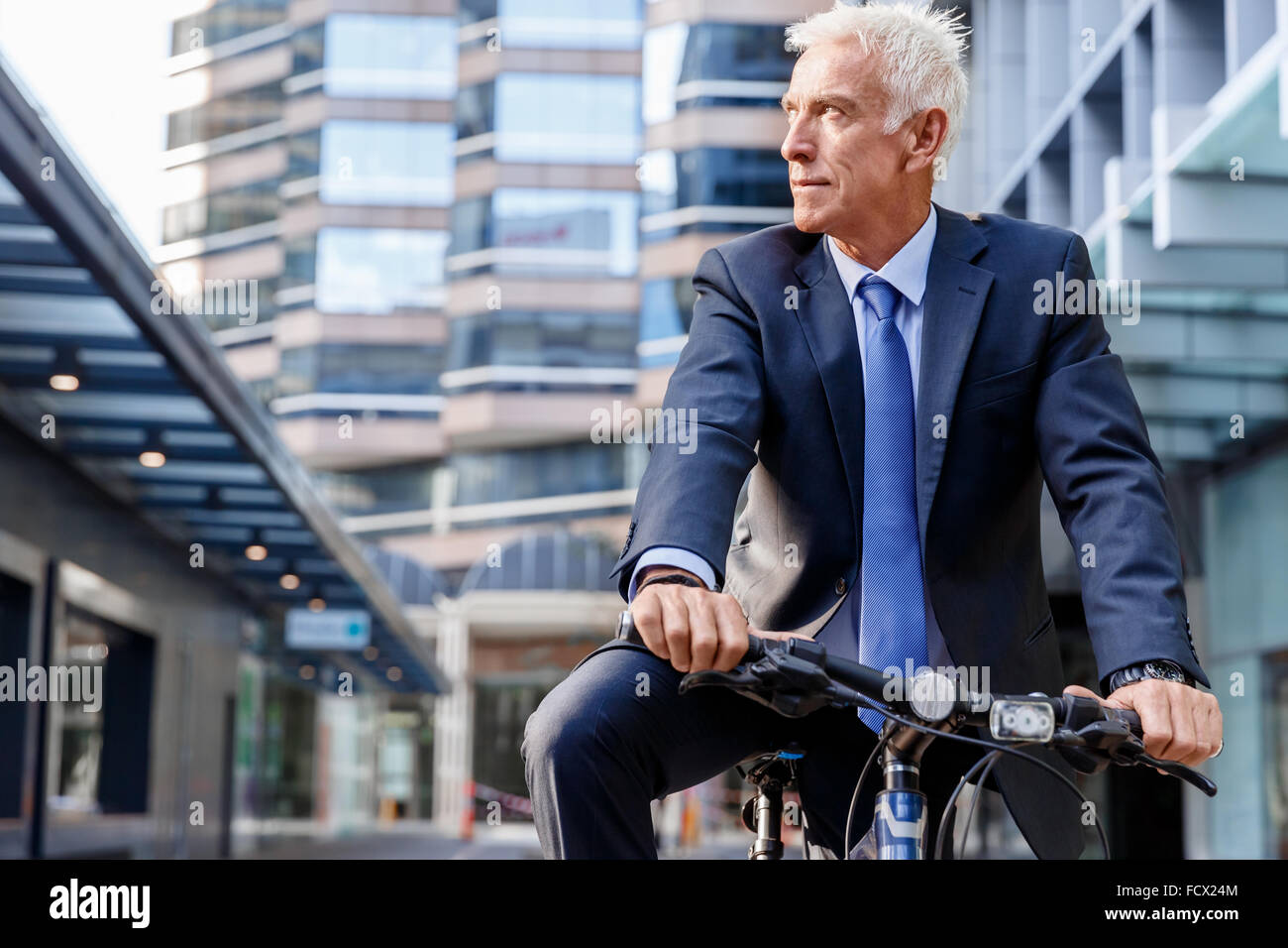Successful businessman in suit riding bicycle Stock Photo - Alamy