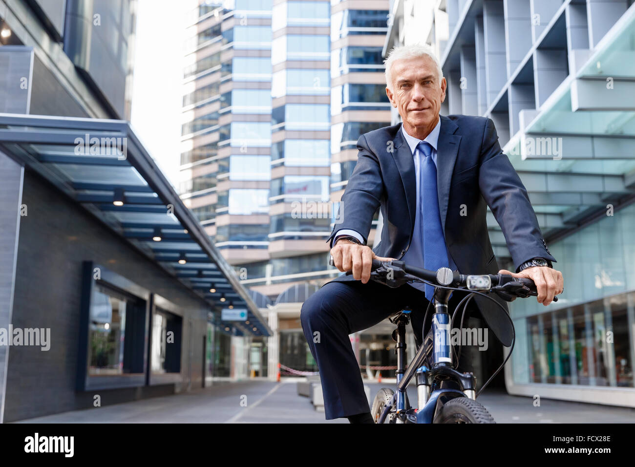 Successful businessman in suit riding bicycle Stock Photo - Alamy