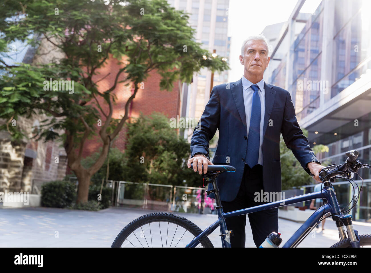 Successful businessman in suit riding bicycle Stock Photo - Alamy