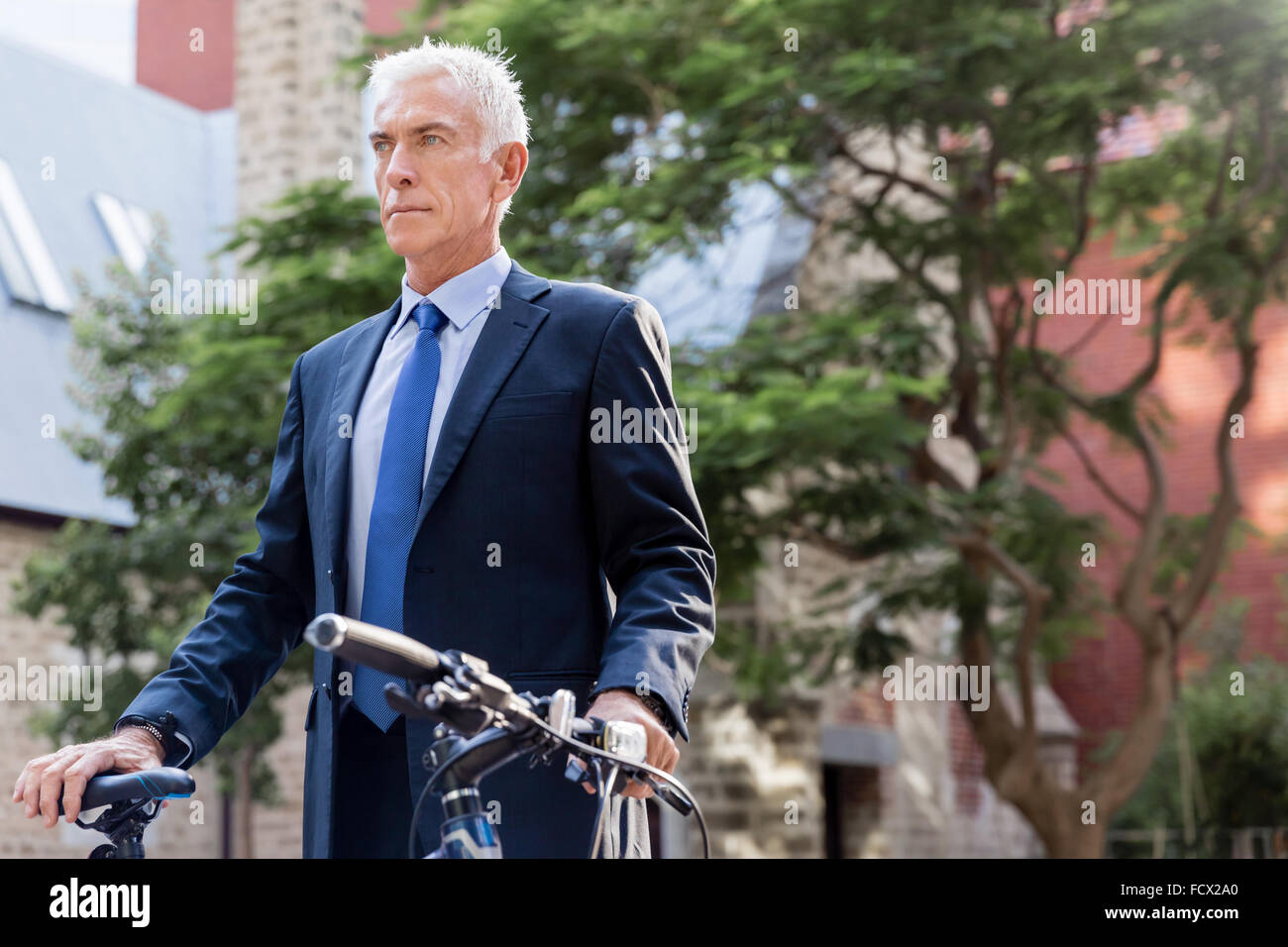Successful businessman in suit riding bicycle Stock Photo - Alamy