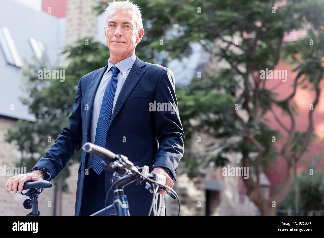 Successful businessman in suit riding bicycle Stock Photo - Alamy