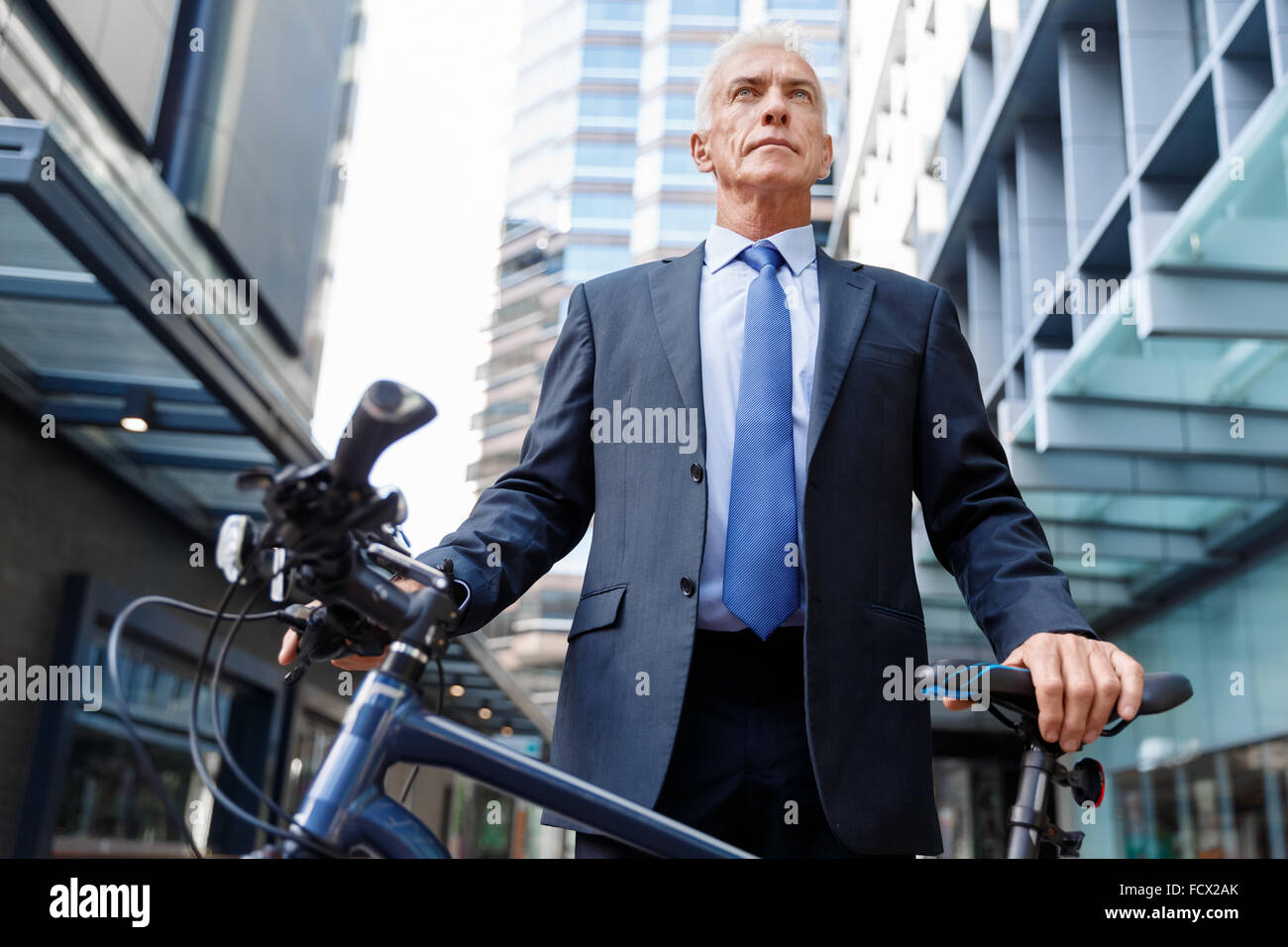 Successful businessman in suit riding bicycle Stock Photo - Alamy