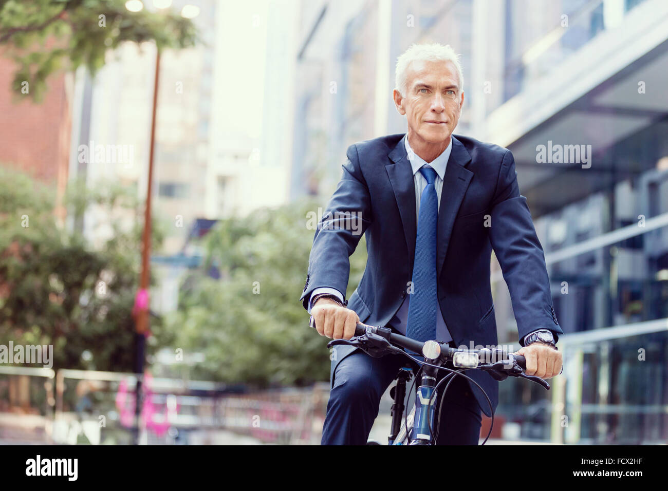 Successful businessman in suit riding bicycle Stock Photo - Alamy