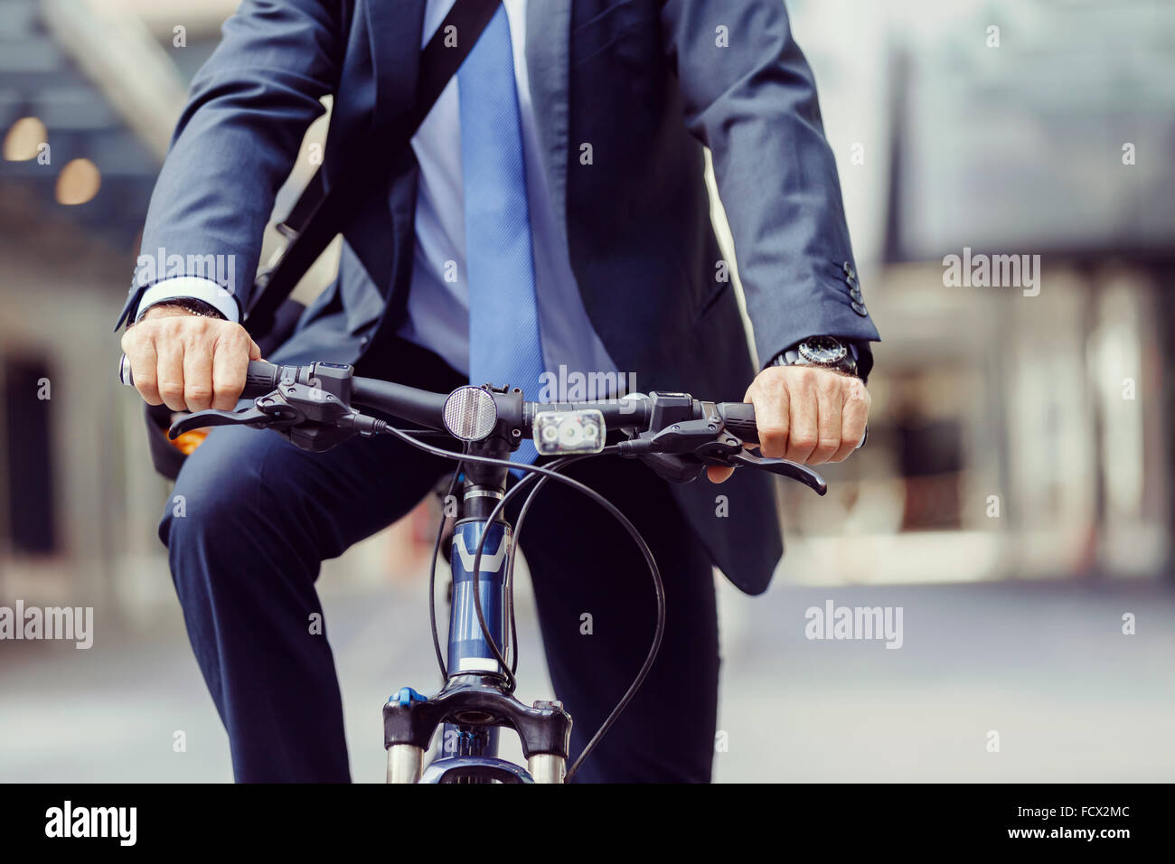 Successful businessman in suit riding bicycle Stock Photo - Alamy