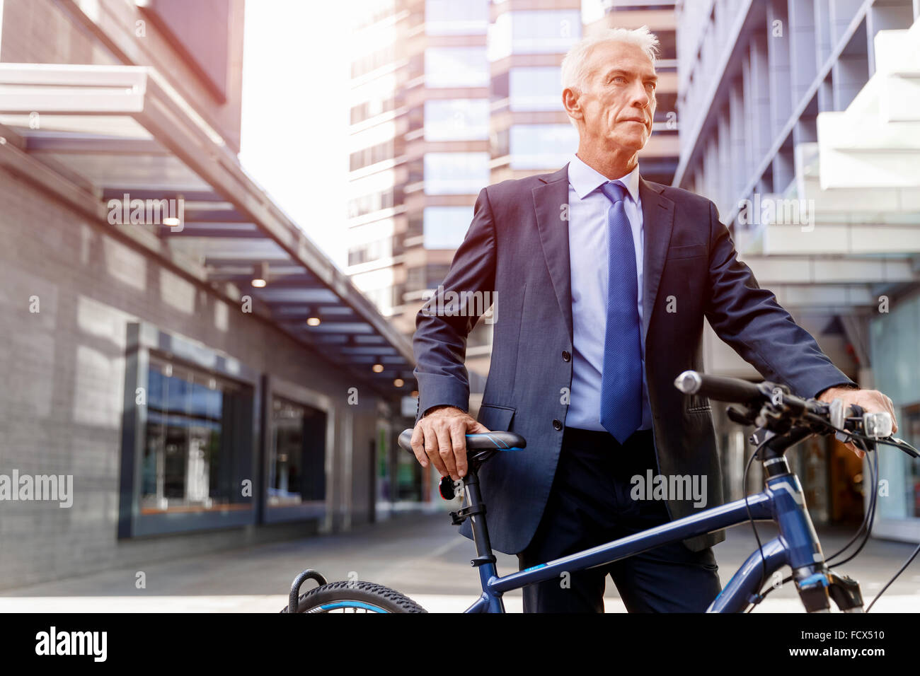 Successful businessman in suit riding bicycle Stock Photo - Alamy
