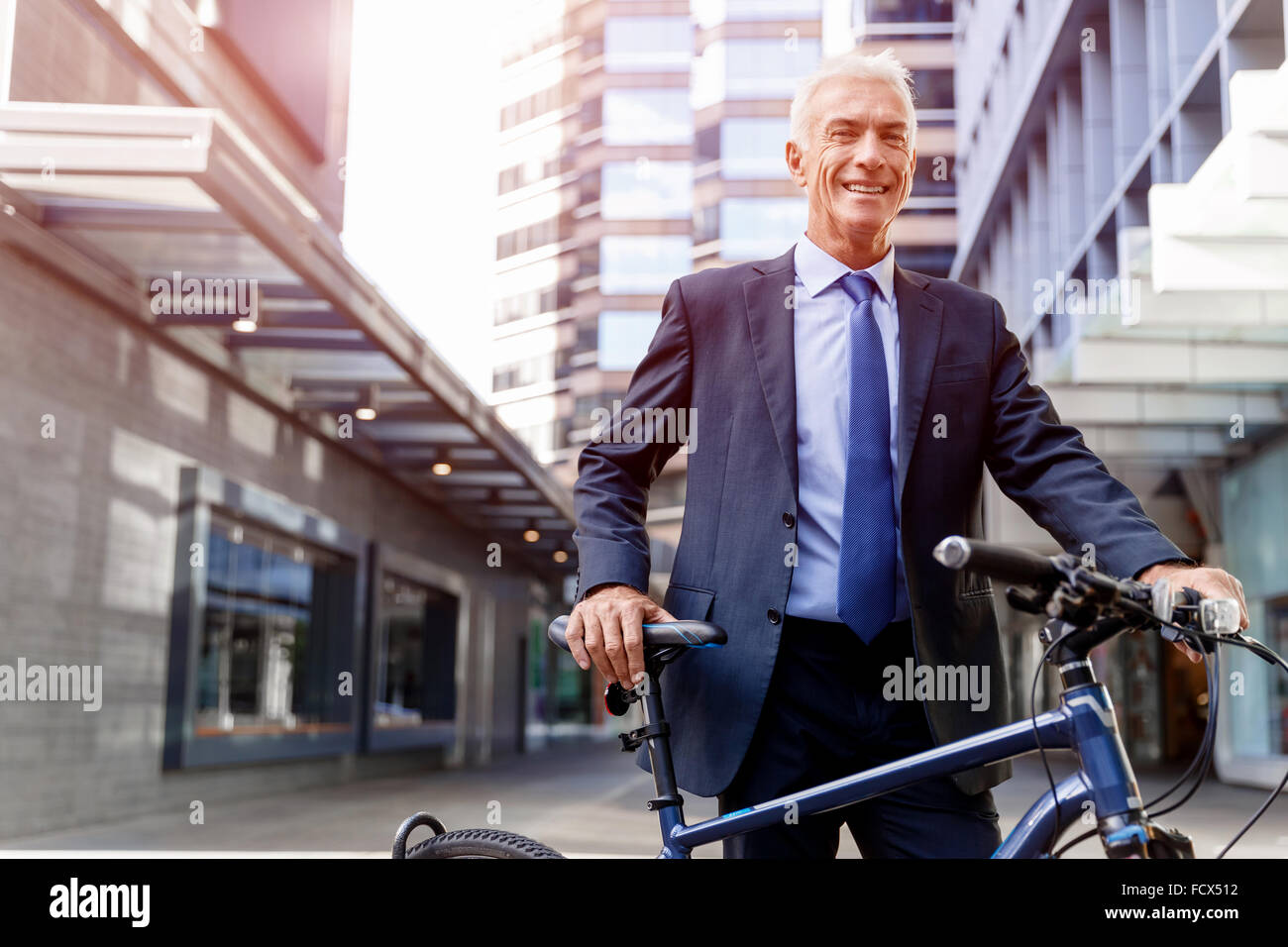 Successful businessman in suit riding bicycle Stock Photo - Alamy