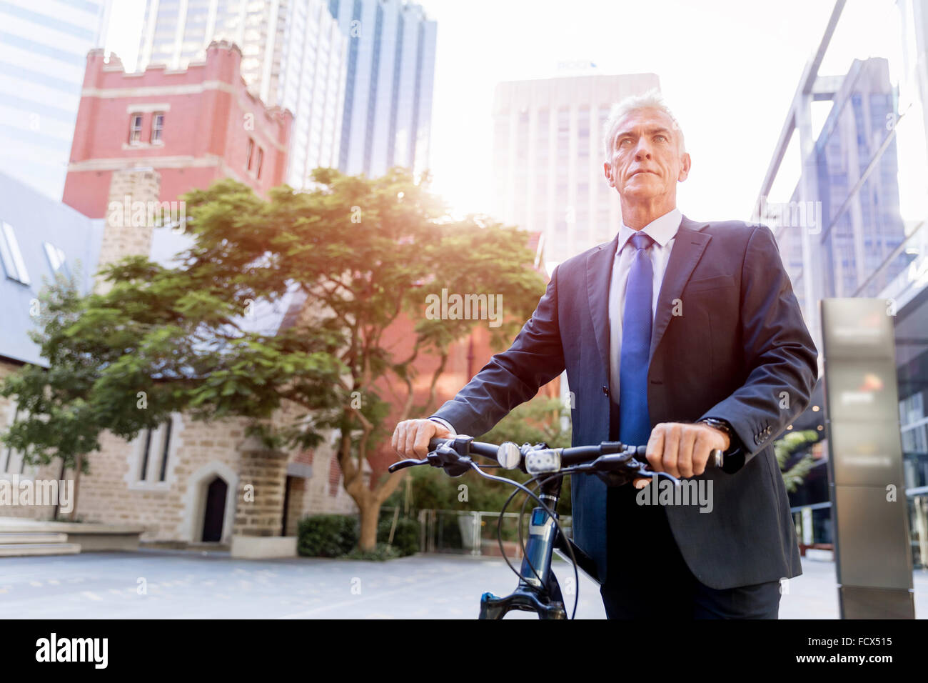 Successful businessman in suit riding bicycle Stock Photo - Alamy