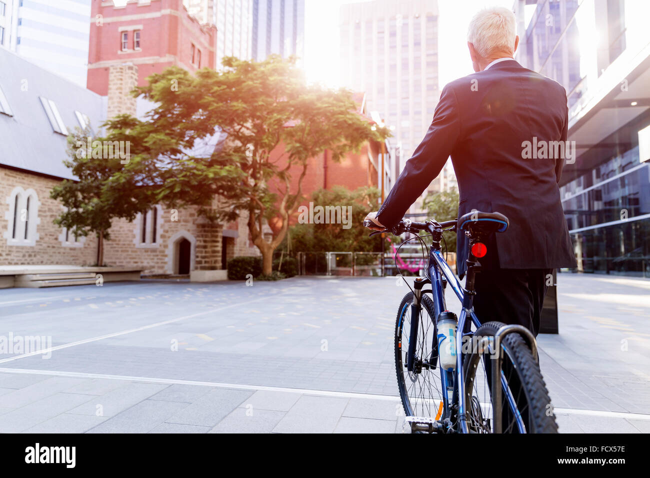 Successful businessman in suit riding bicycle Stock Photo - Alamy
