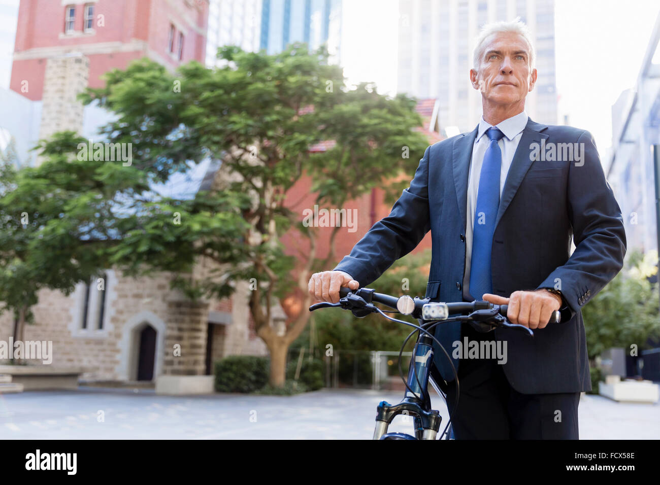 Successful businessman in suit riding bicycle Stock Photo - Alamy