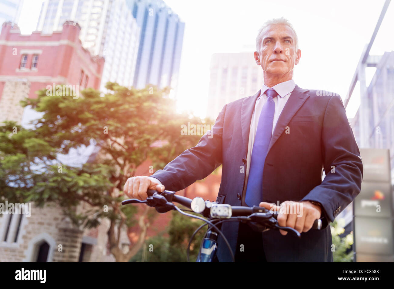 Successful businessman in suit riding bicycle Stock Photo - Alamy