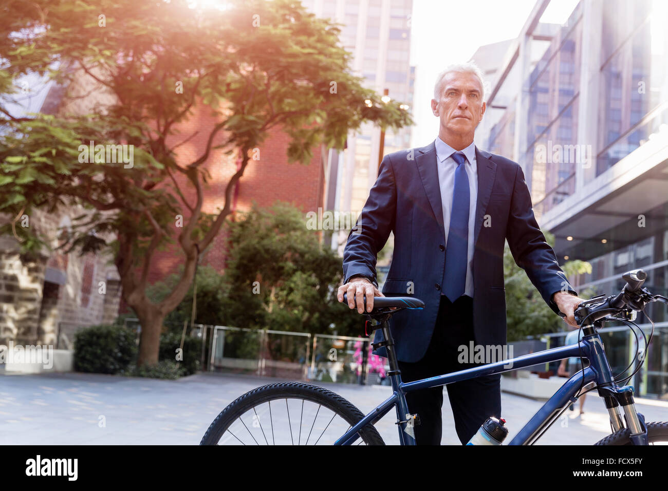 Successful businessman in suit riding bicycle Stock Photo - Alamy