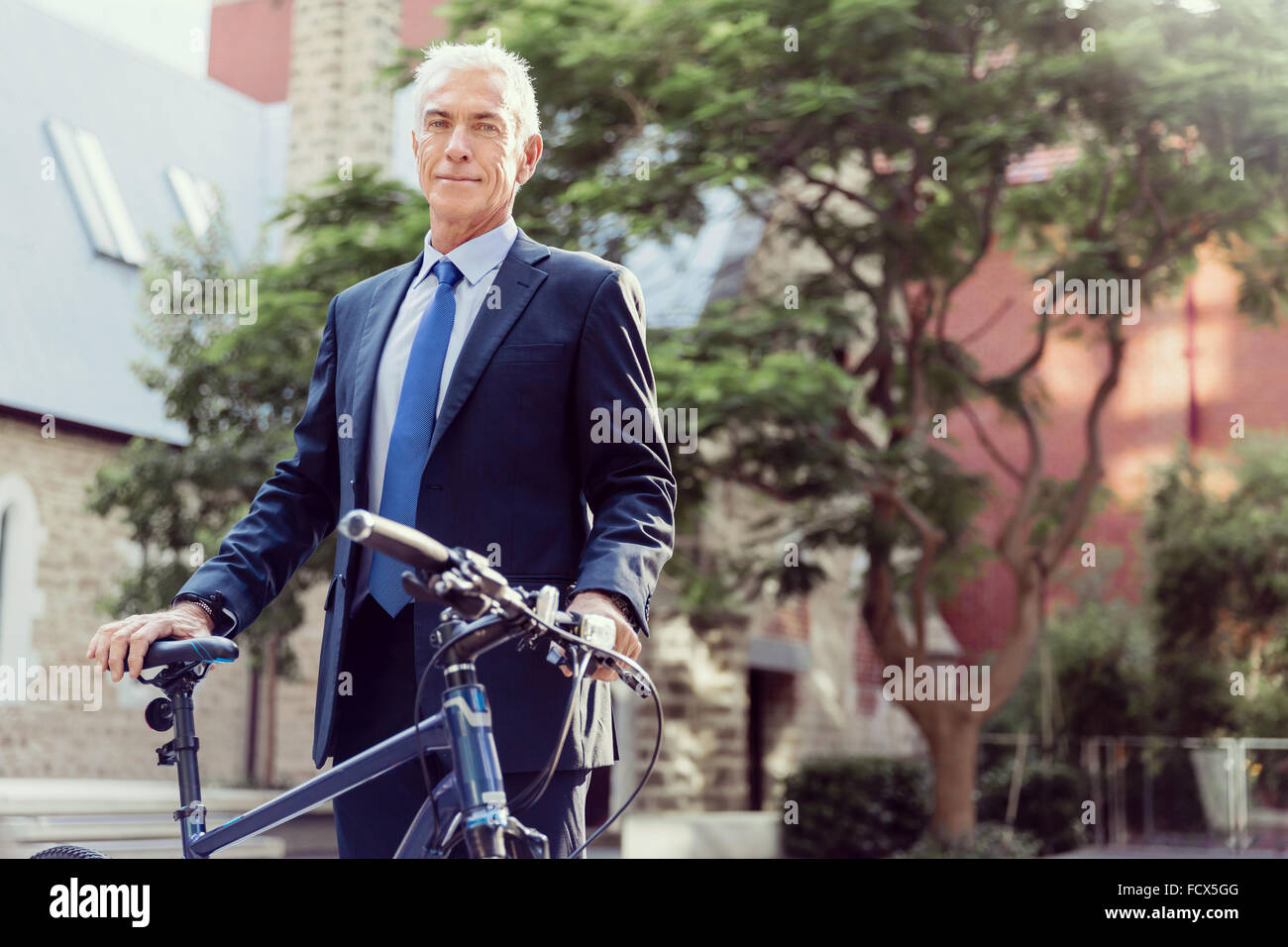 Successful businessman in suit riding bicycle Stock Photo - Alamy
