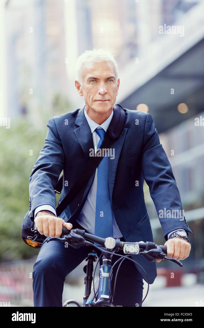 Successful businessman in suit riding bicycle Stock Photo - Alamy