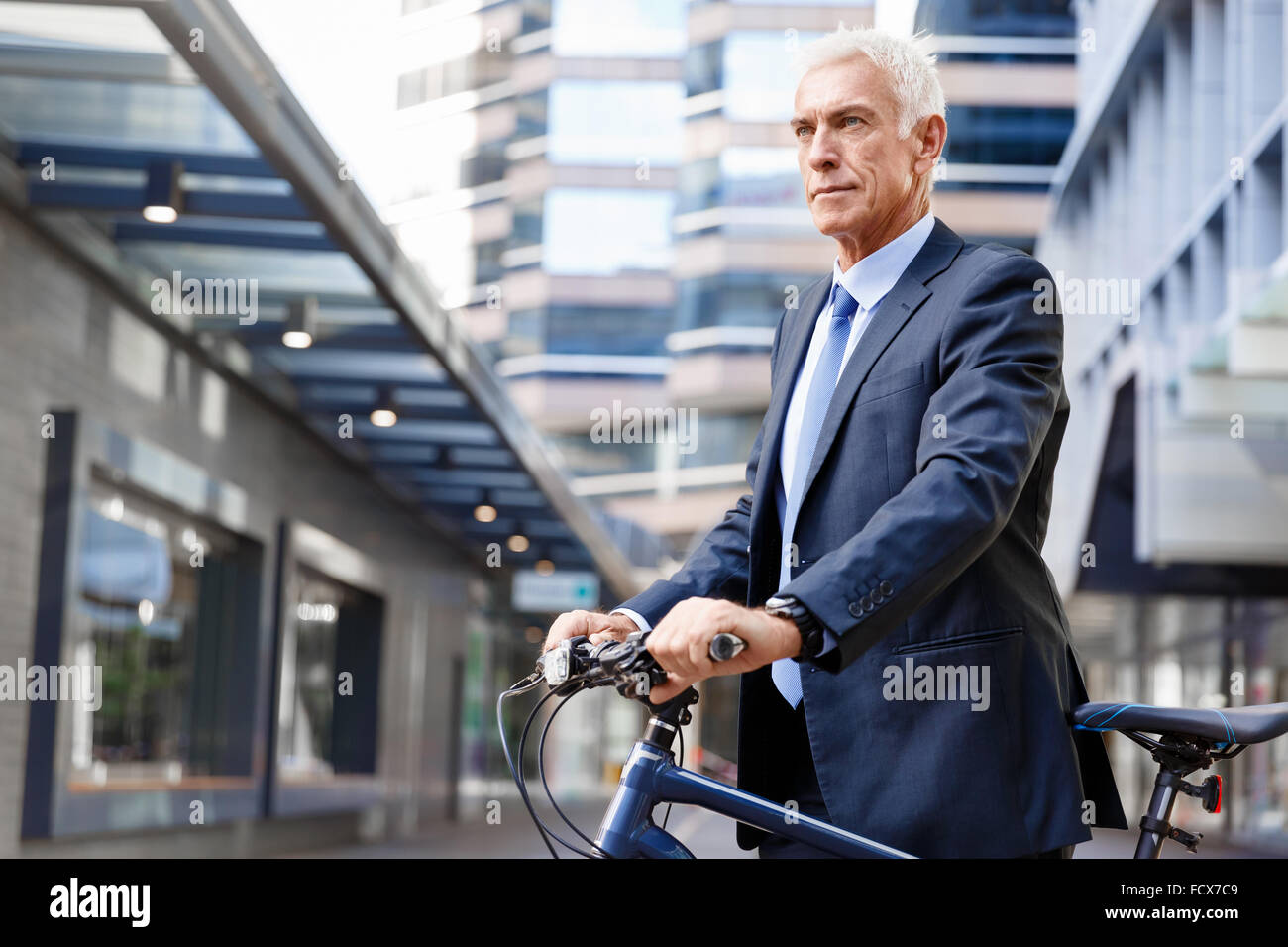 Successful businessman in suit riding bicycle Stock Photo - Alamy