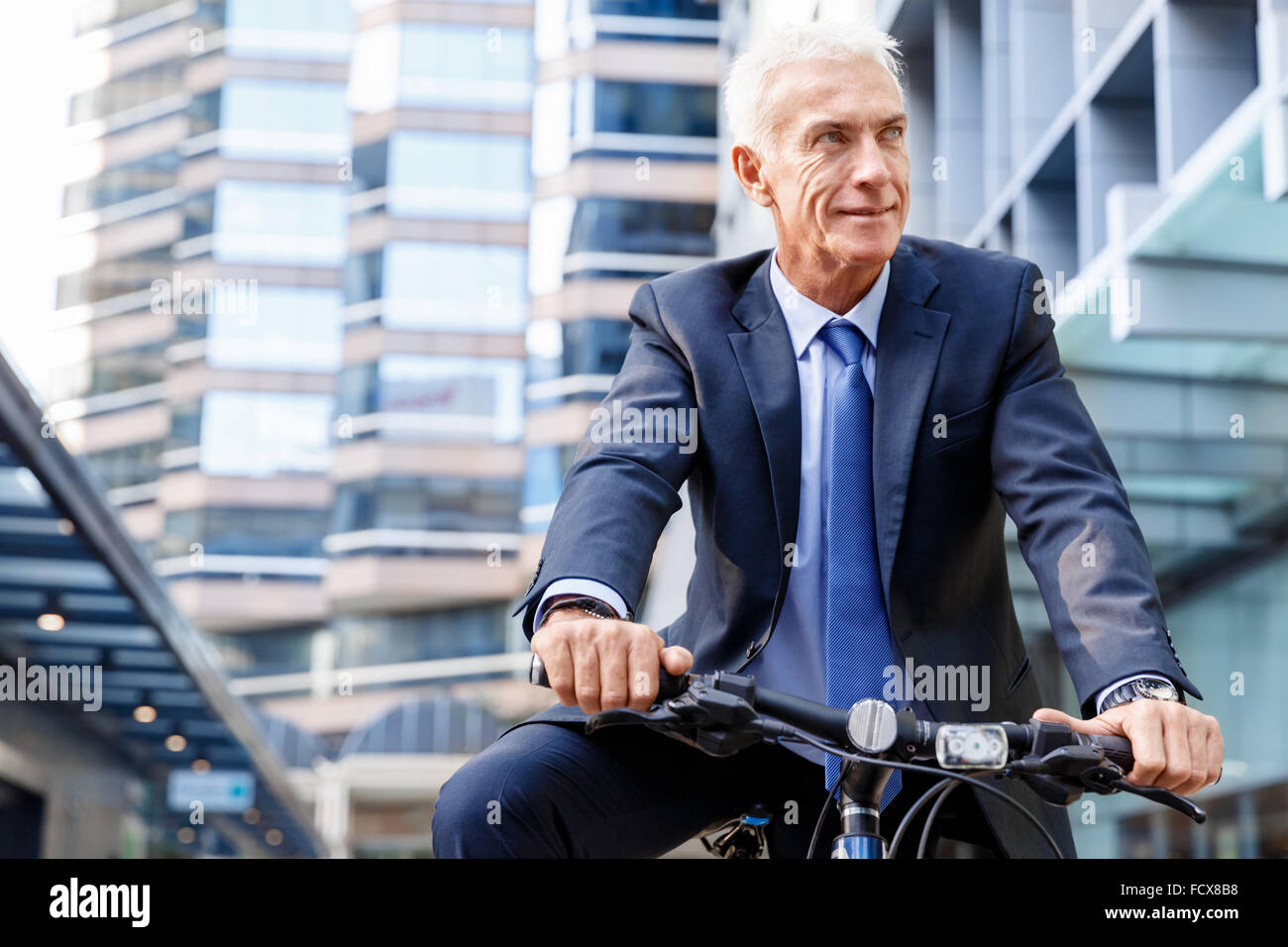 Successful businessman in suit riding bicycle Stock Photo - Alamy